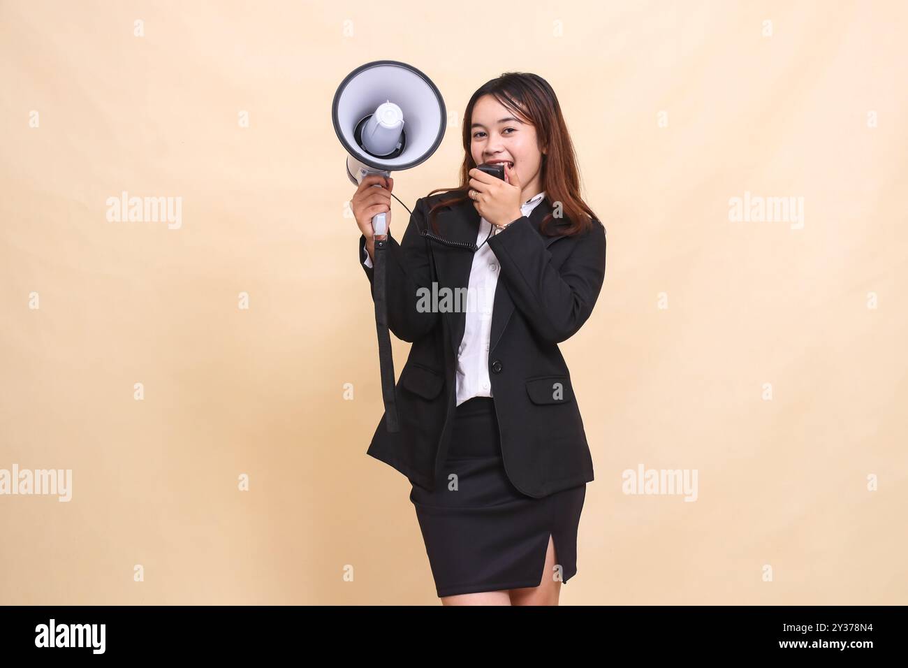 Beautiful formal asian office girl in suit standing happy shouting into ...