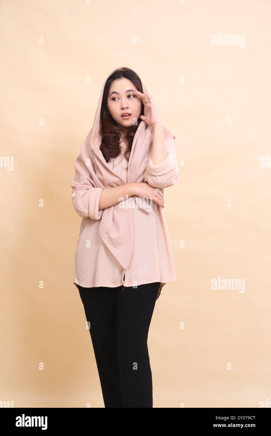 Elegant Asian semi-hijab woman standing candid, headache, arms holding ...