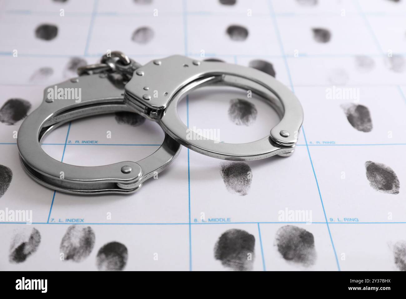 Human fingerprints and handcuffs on paper, closeup. Criminal conviction ...
