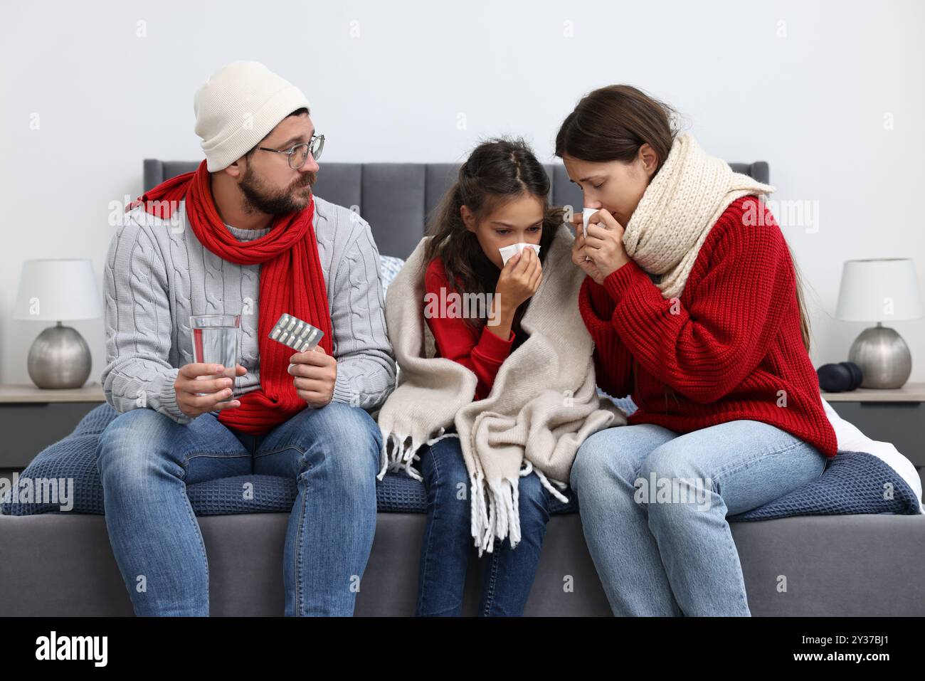 Cold symptom. Family suffering from fever on bed at home Stock Photo ...