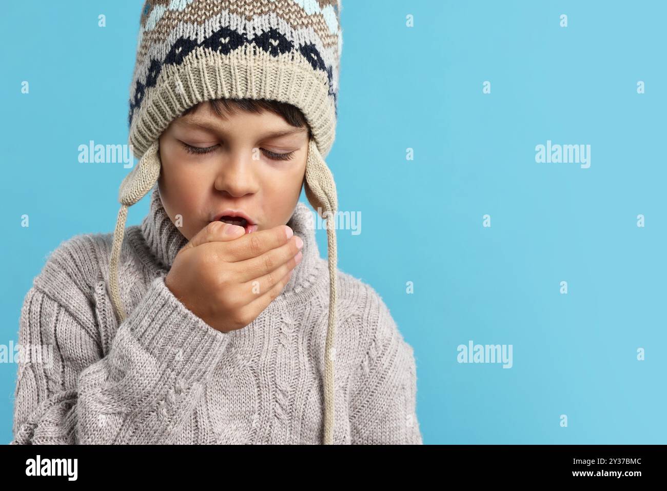 Cold symptom. Little boy suffering from fever on light blue background ...