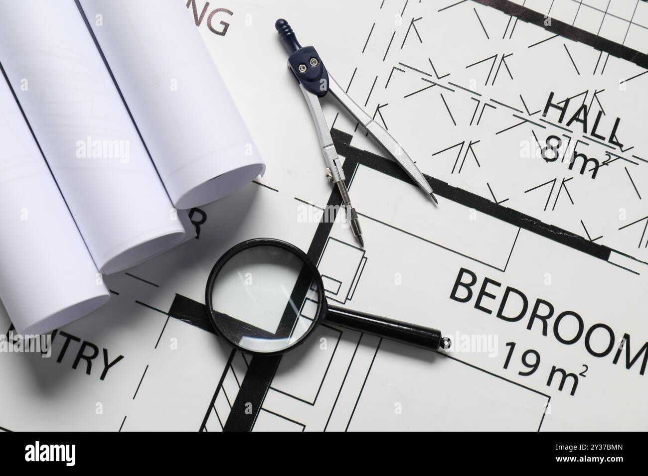 Dividers and magnifying glass on different engineering drawings, top ...