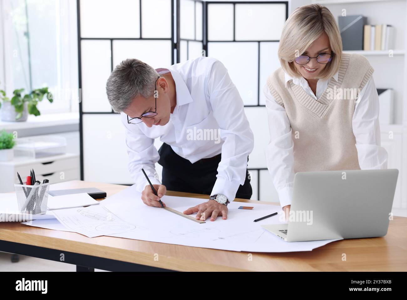 Architects making engineering drawing at wooden table in office Stock ...