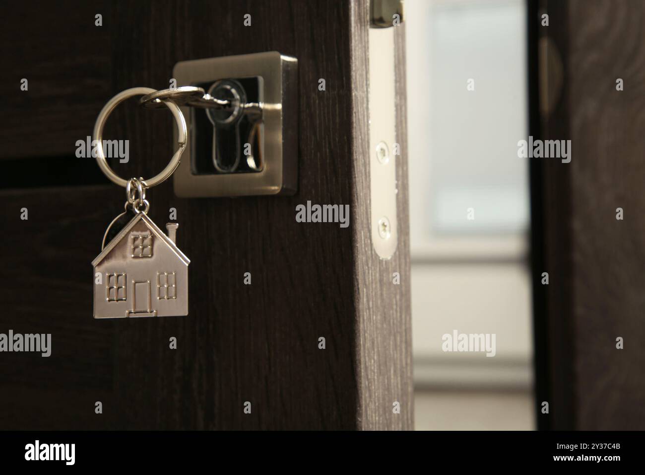 Open door with key and house shaped keychain, closeup Stock Photo - Alamy