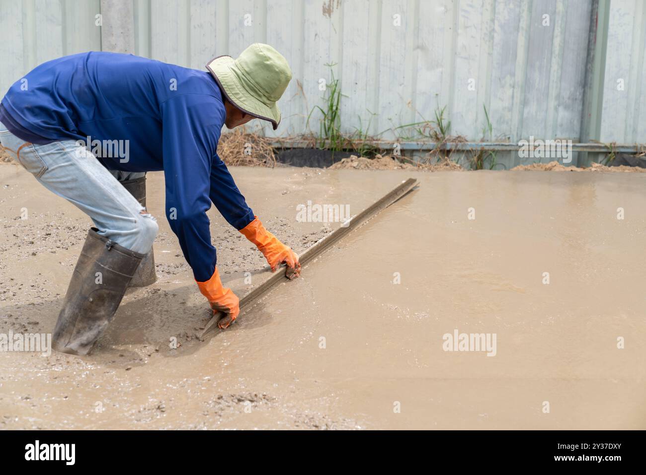 Worker plastering wet concrete surface after pouring concrete floor in ...
