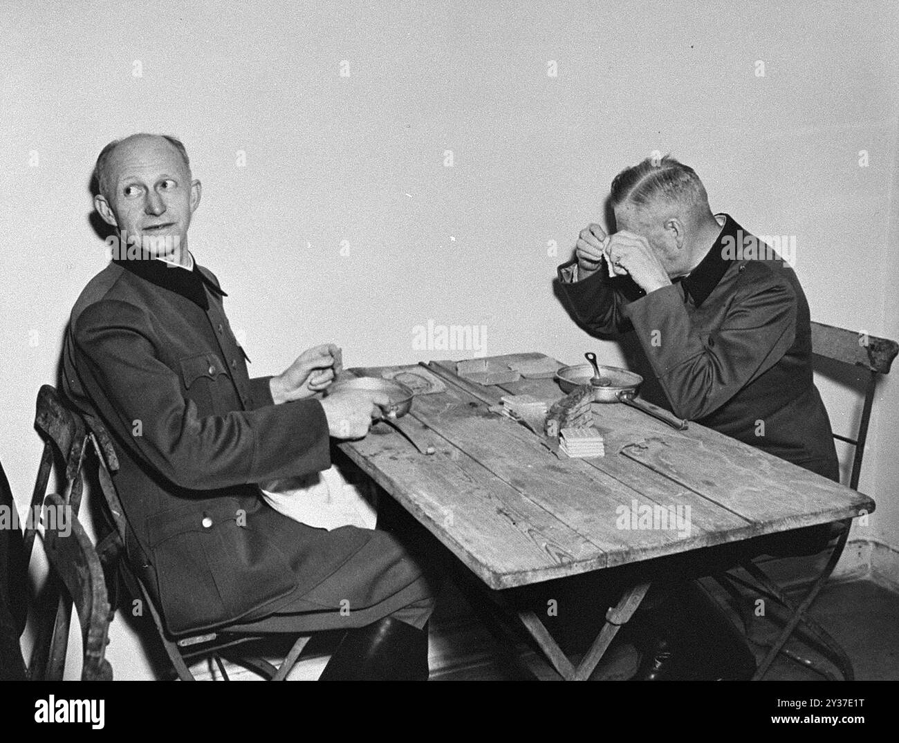 Alfred Jodl (left) and Wilhelm Keitel (right) eat in a makeshift dining ...