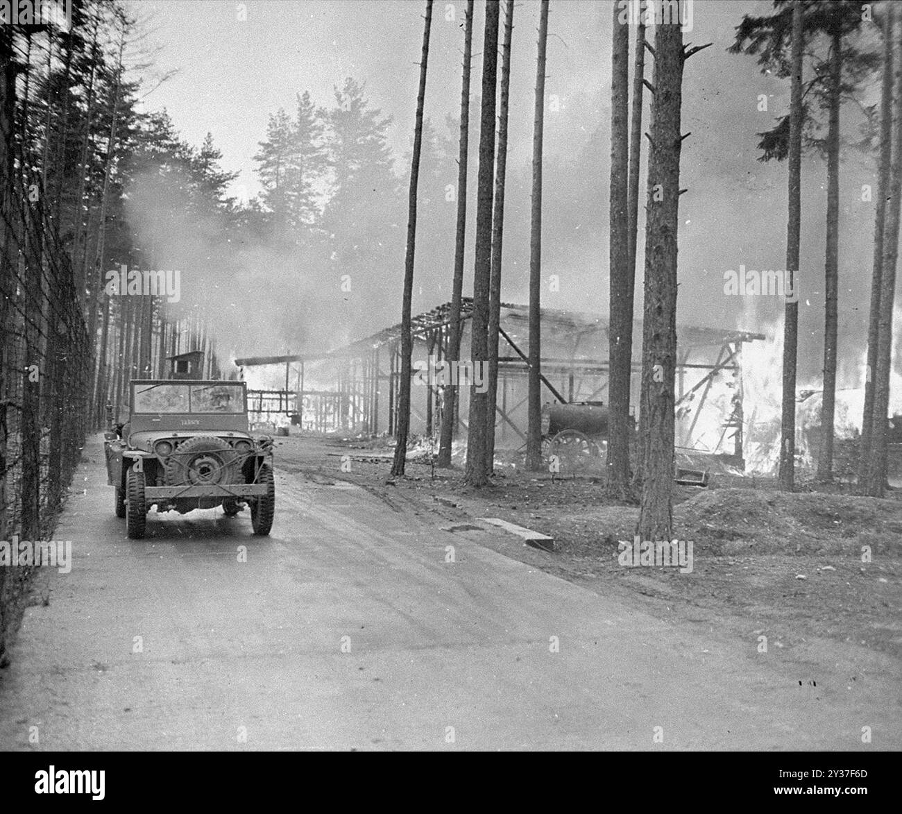An American soldier drives past buildings set afire by survivors after ...