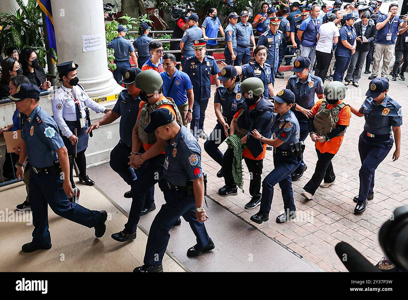 People, in green helmet, charged with human trafficking, enter the ...