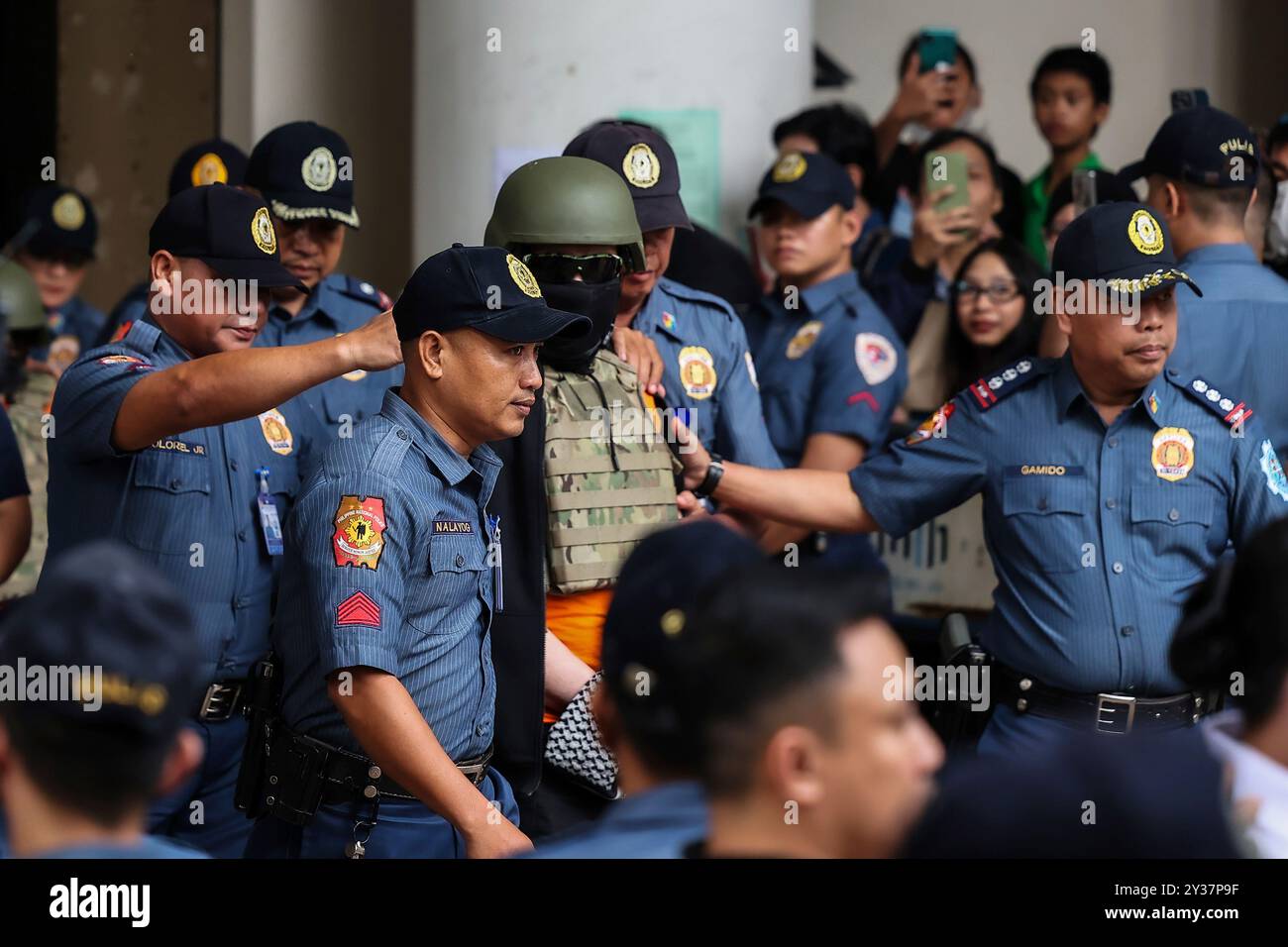 Apollo Carreon Quiboloy, center, wearing a helmet and flak jacket, a ...