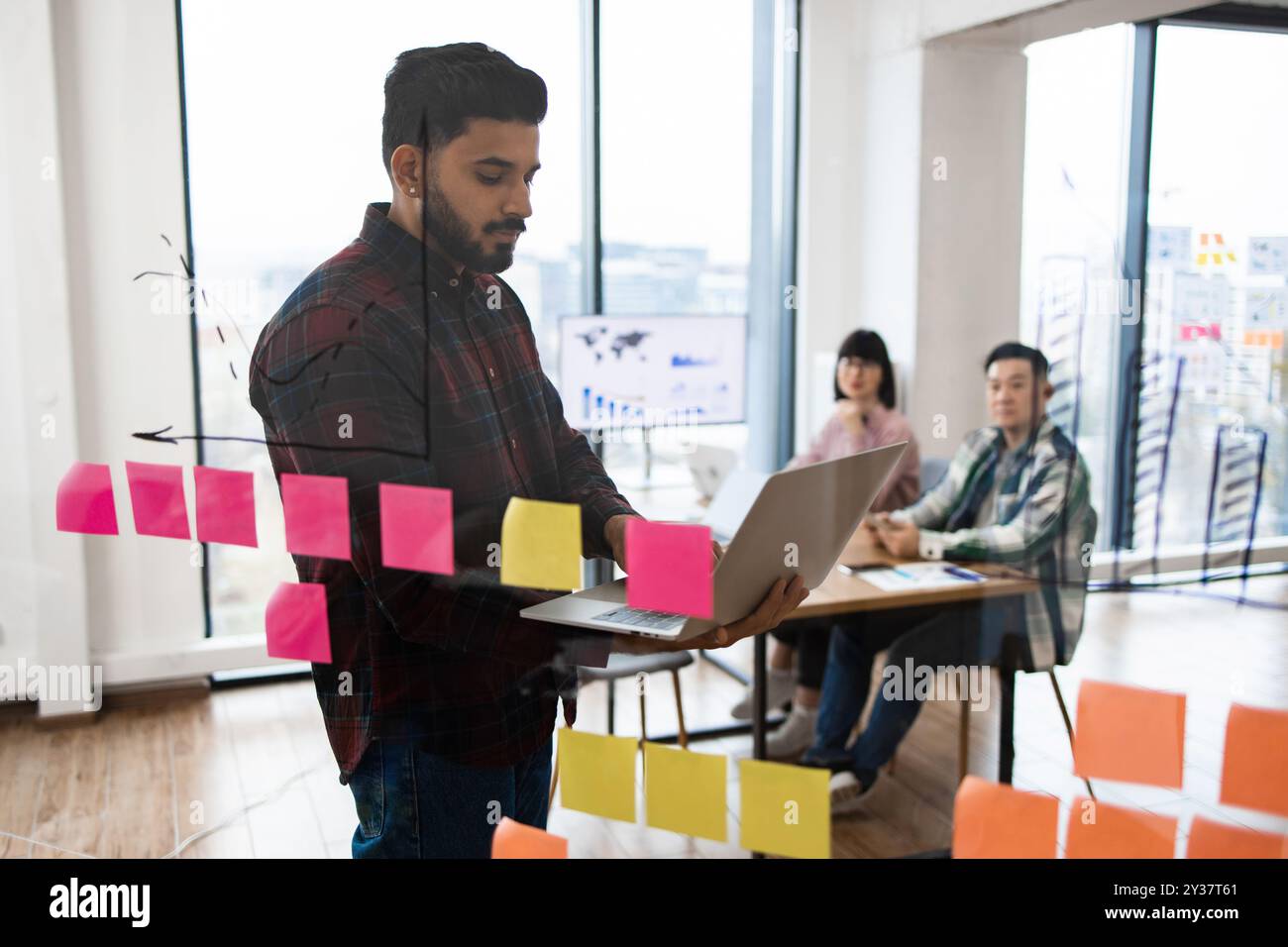 Team brainstorming session with sticky notes and laptop in office Stock ...