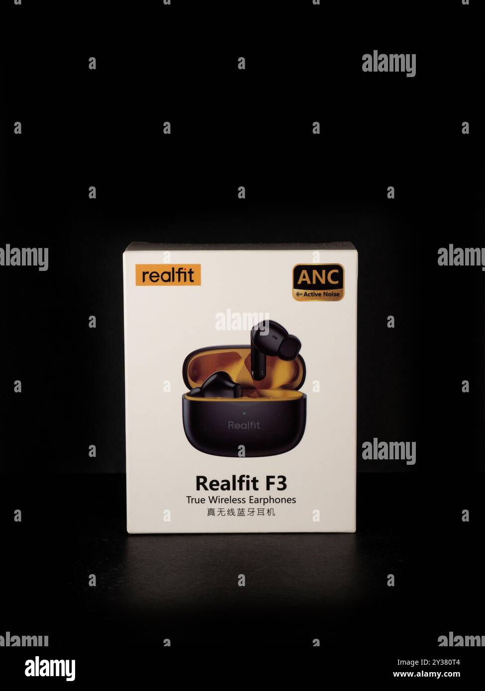 Realfit F3 wireless earphones packaging against dark background ...