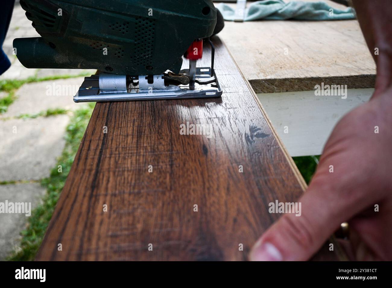 Construction worker is cutting a laminate floor panel using a jigsaw ...