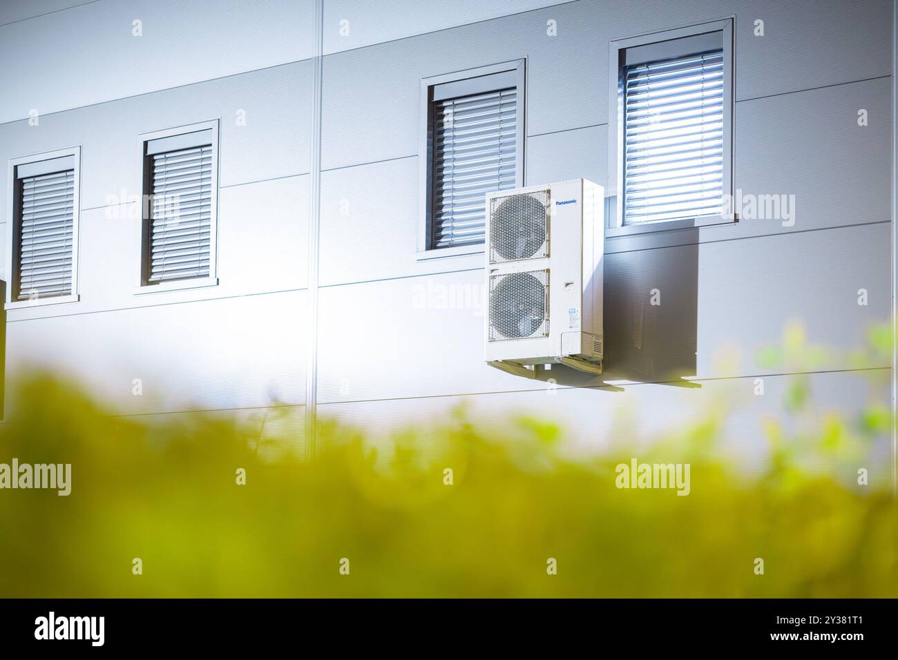 Two industrial grade external AC units with fans resting on modern ...