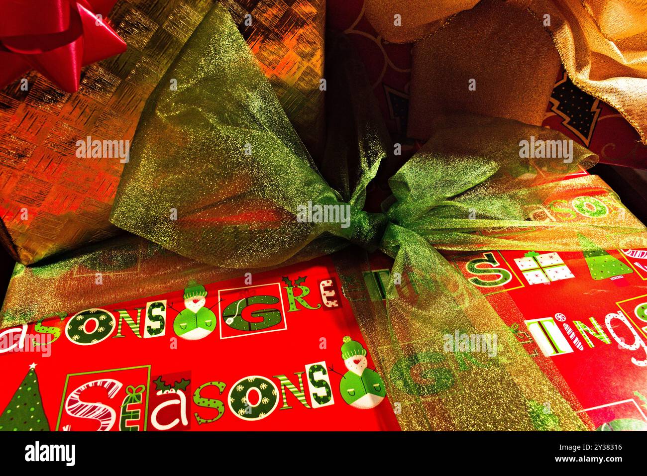 Three wrapped Christmas gifts stacked on top of one another. Primary ...