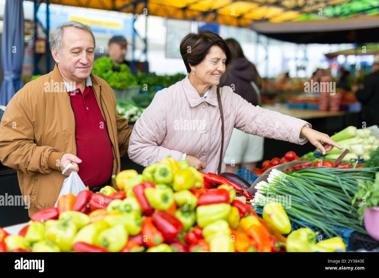Happy mature male and female picking fresh organic vegetables during ...