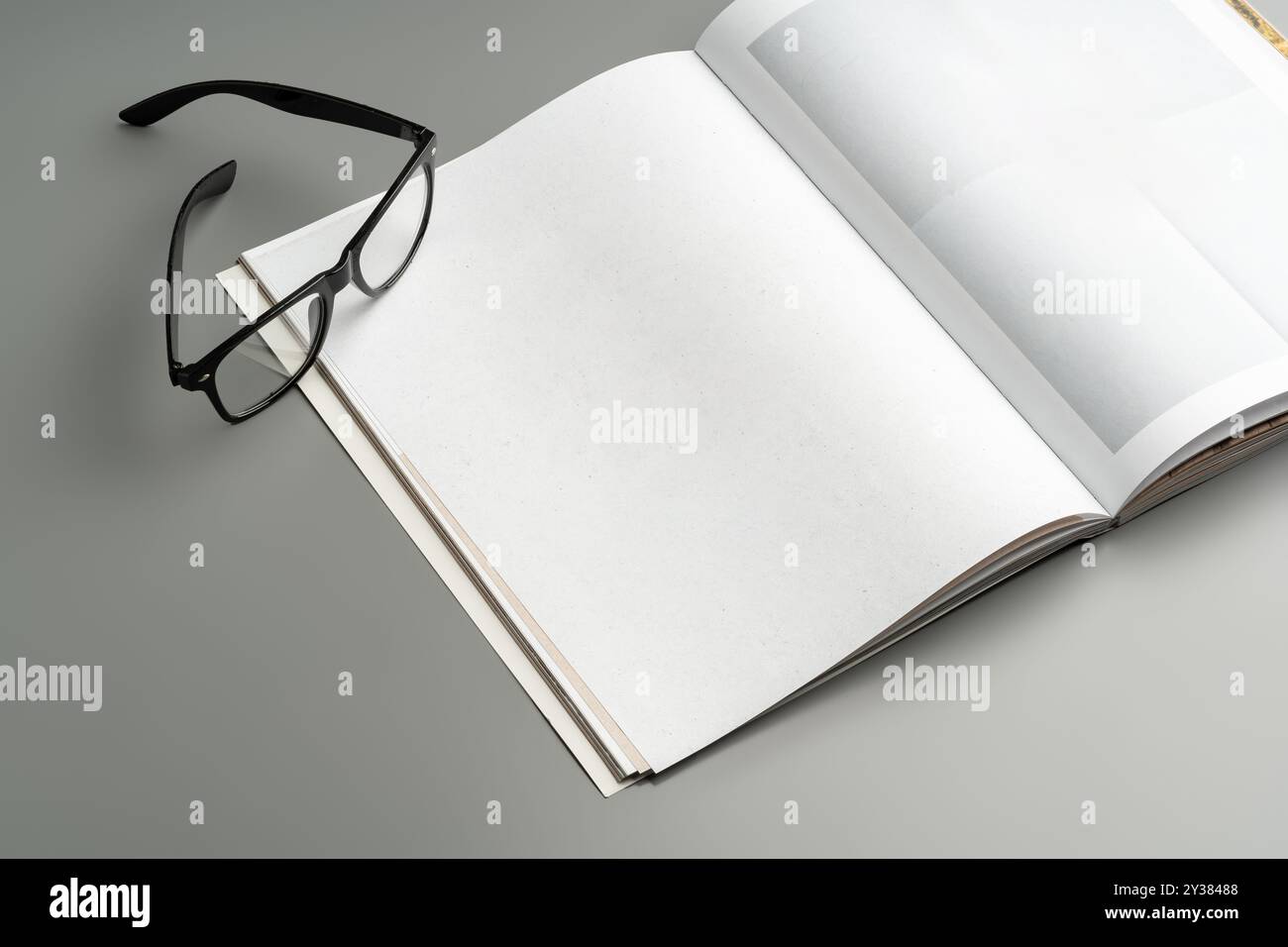 A blank open notebook resting on a neutral background during daylight ...