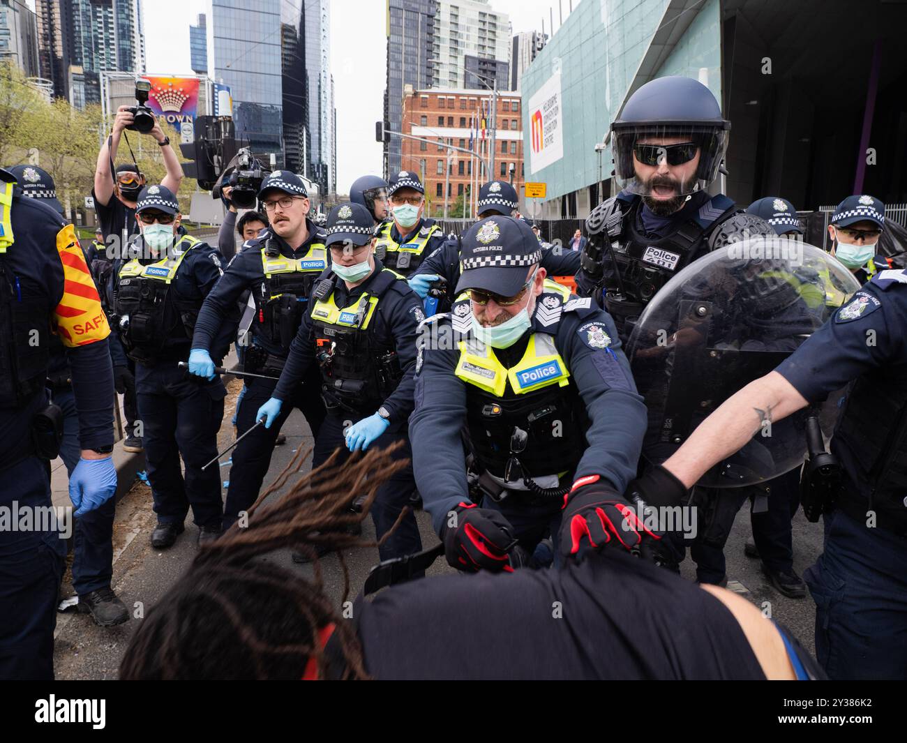 Officers shove a protester to the ground after he tries to help a ...