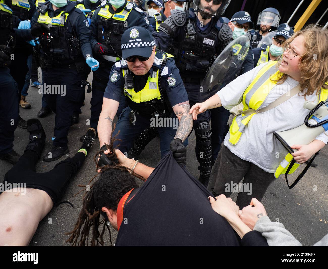 A police officer pulls a man by his hair after he attempted to pull a ...