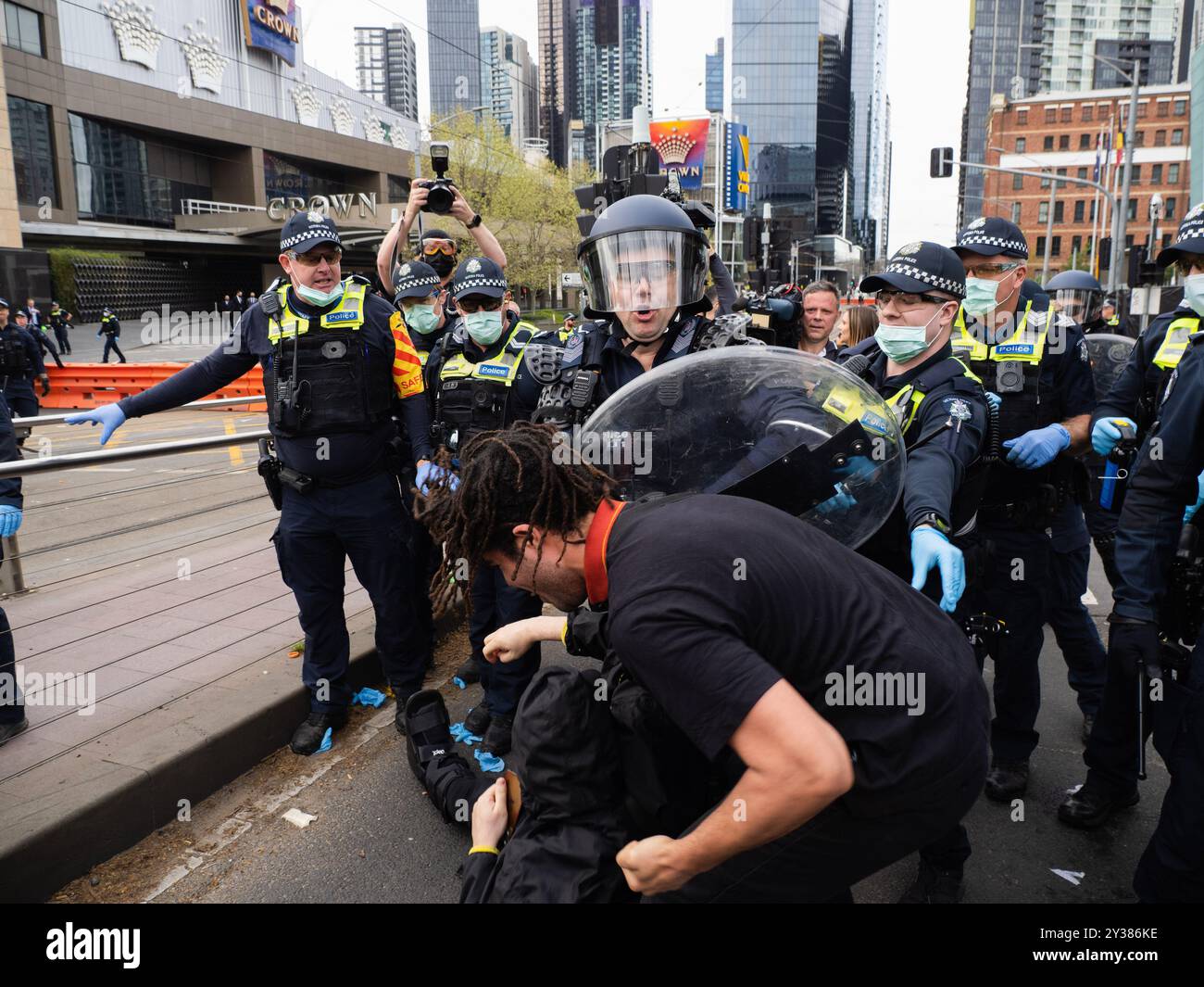 Officers shove a protester to the ground after he tries to help a ...