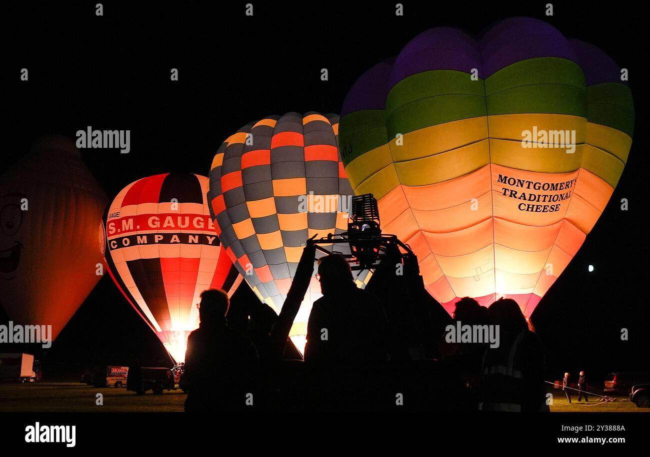 Hot air balloons take part in a night glow during a preview for Icons ...