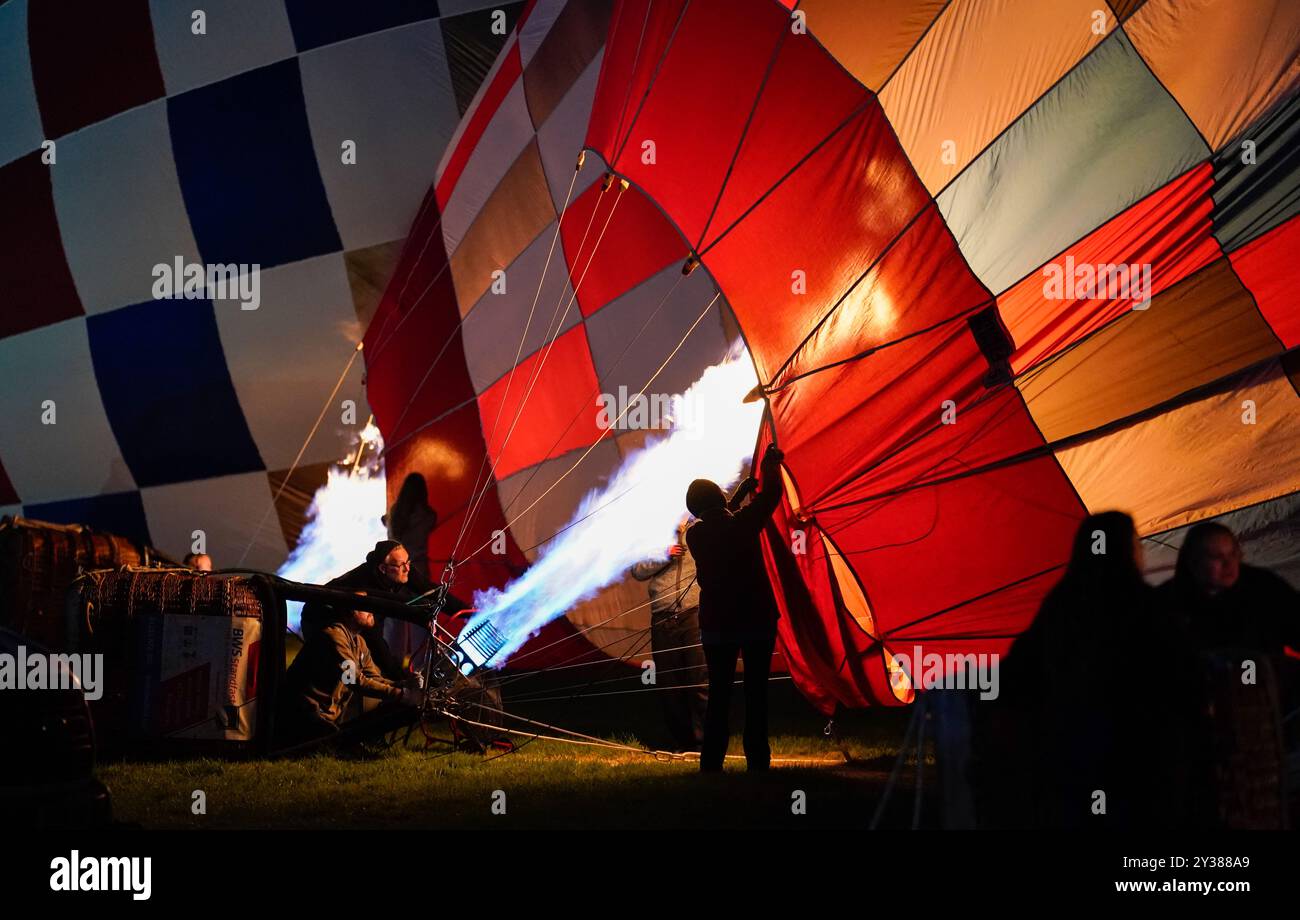 Hot air balloon crews prepare their balloons to take part in a night ...