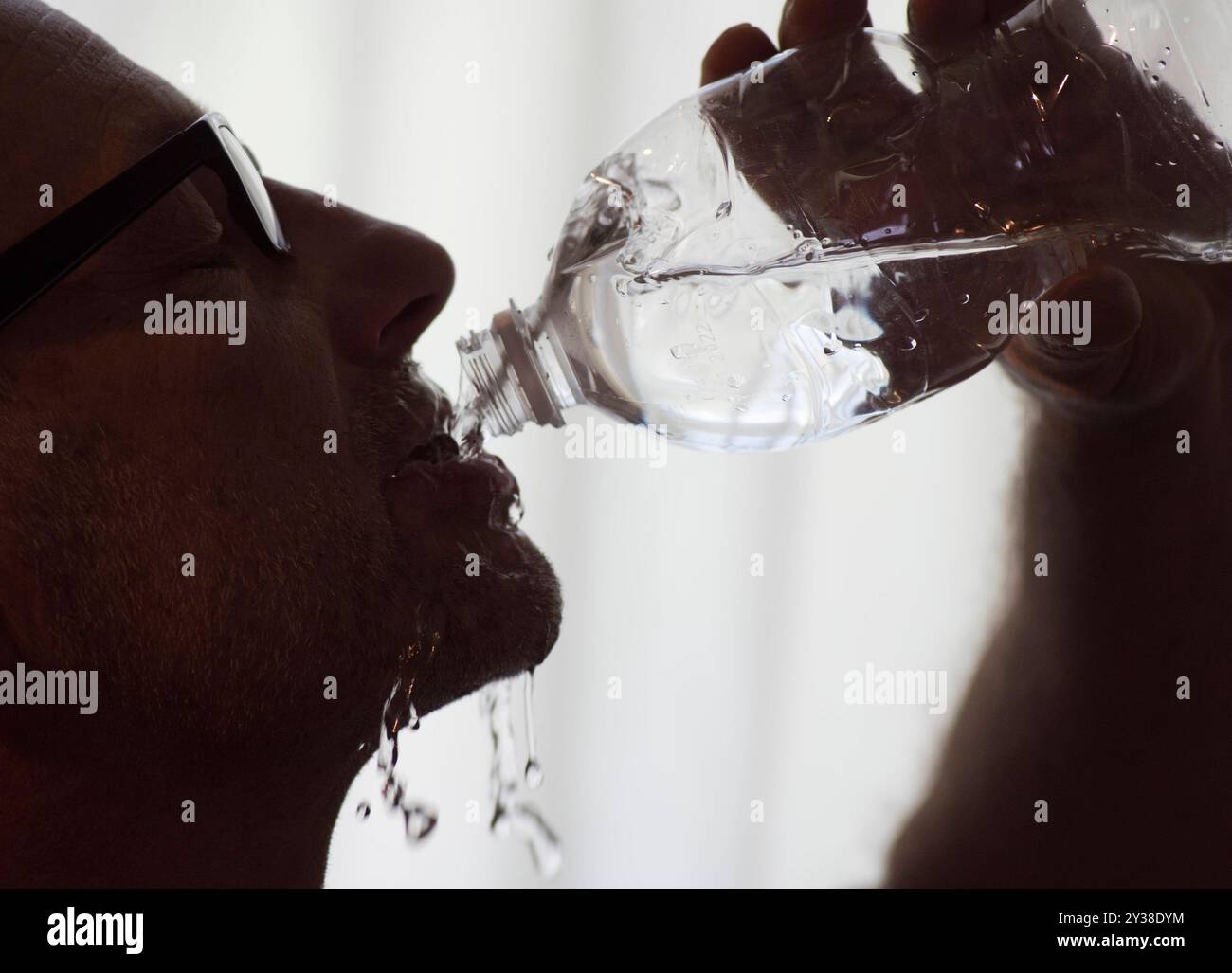 drinking water from a plastic bottle, liquid supply and thirst on a hot ...