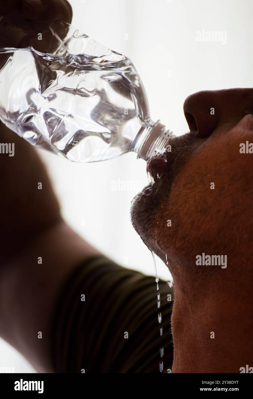 drinking water from a plastic bottle, liquid supply and thirst on a hot ...