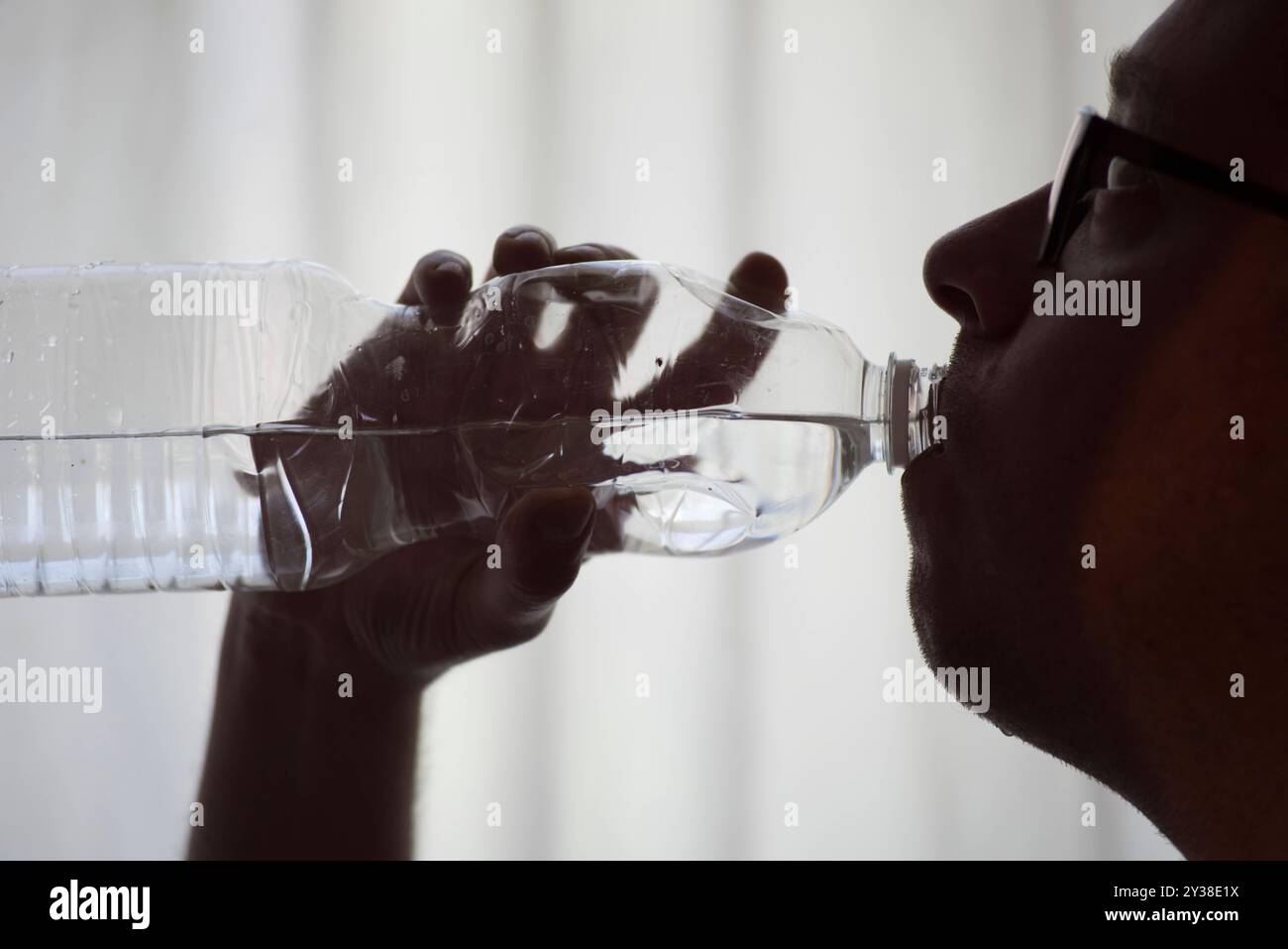drinking water from a plastic bottle, liquid supply and thirst on a hot ...