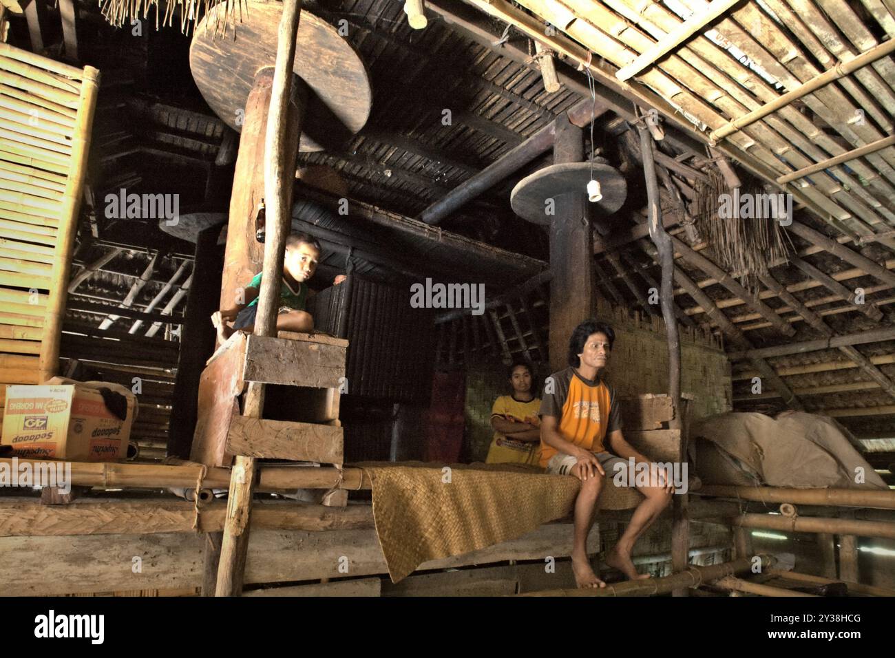 Umbu Tiu, a villager, with his wife and child inside their traditional ...
