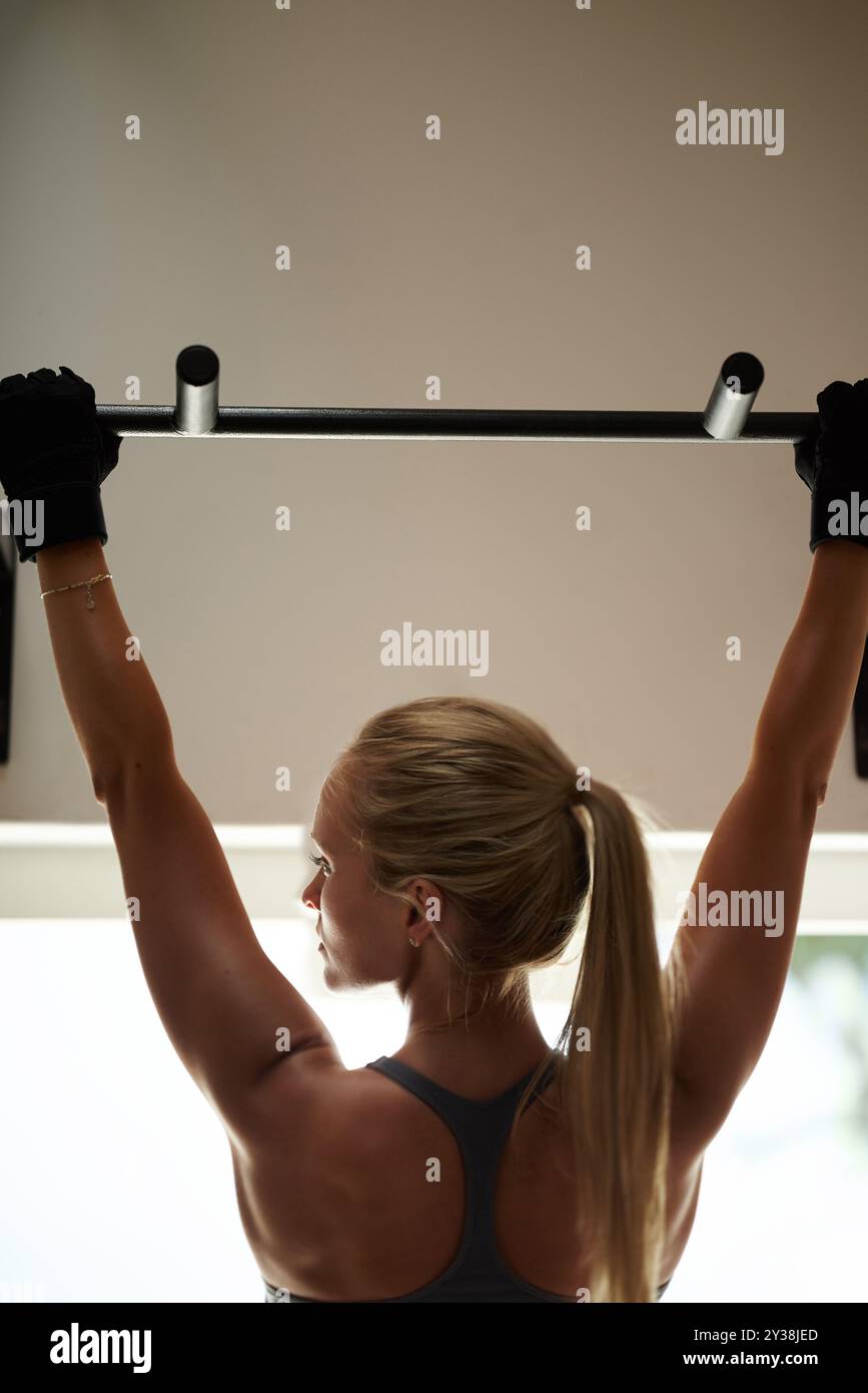 Back, pull up and woman in gym for exercise, power and workout for ...