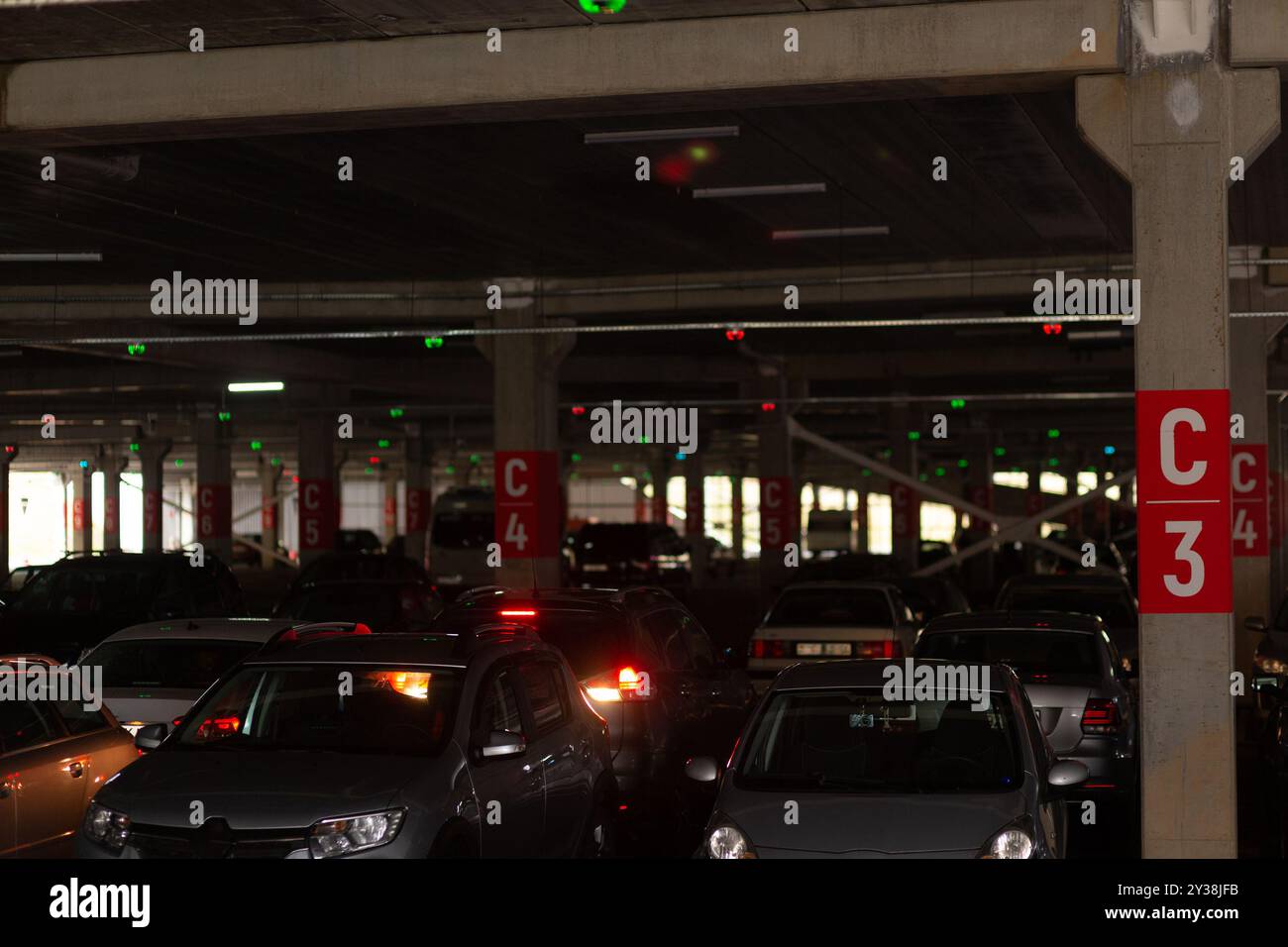 Neon multi-level underground parking in a shopping center. Covered ...