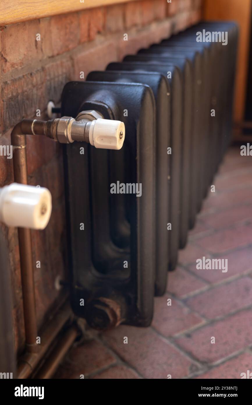 Classic metallic radiator installed in a cozy indoor space with exposed ...