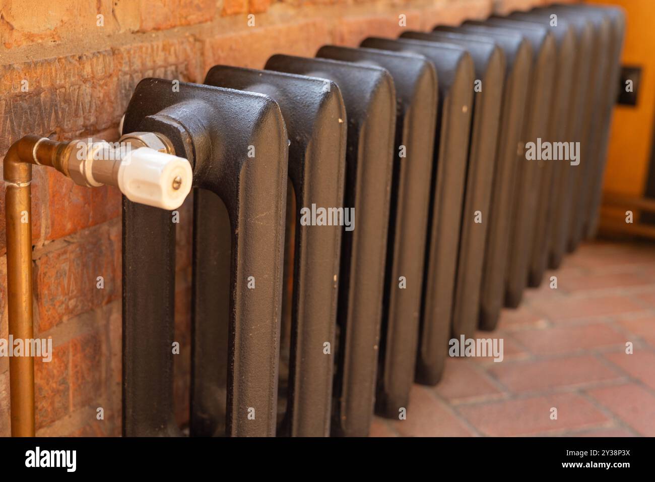 Classic metallic radiator installed in a cozy indoor space with exposed ...