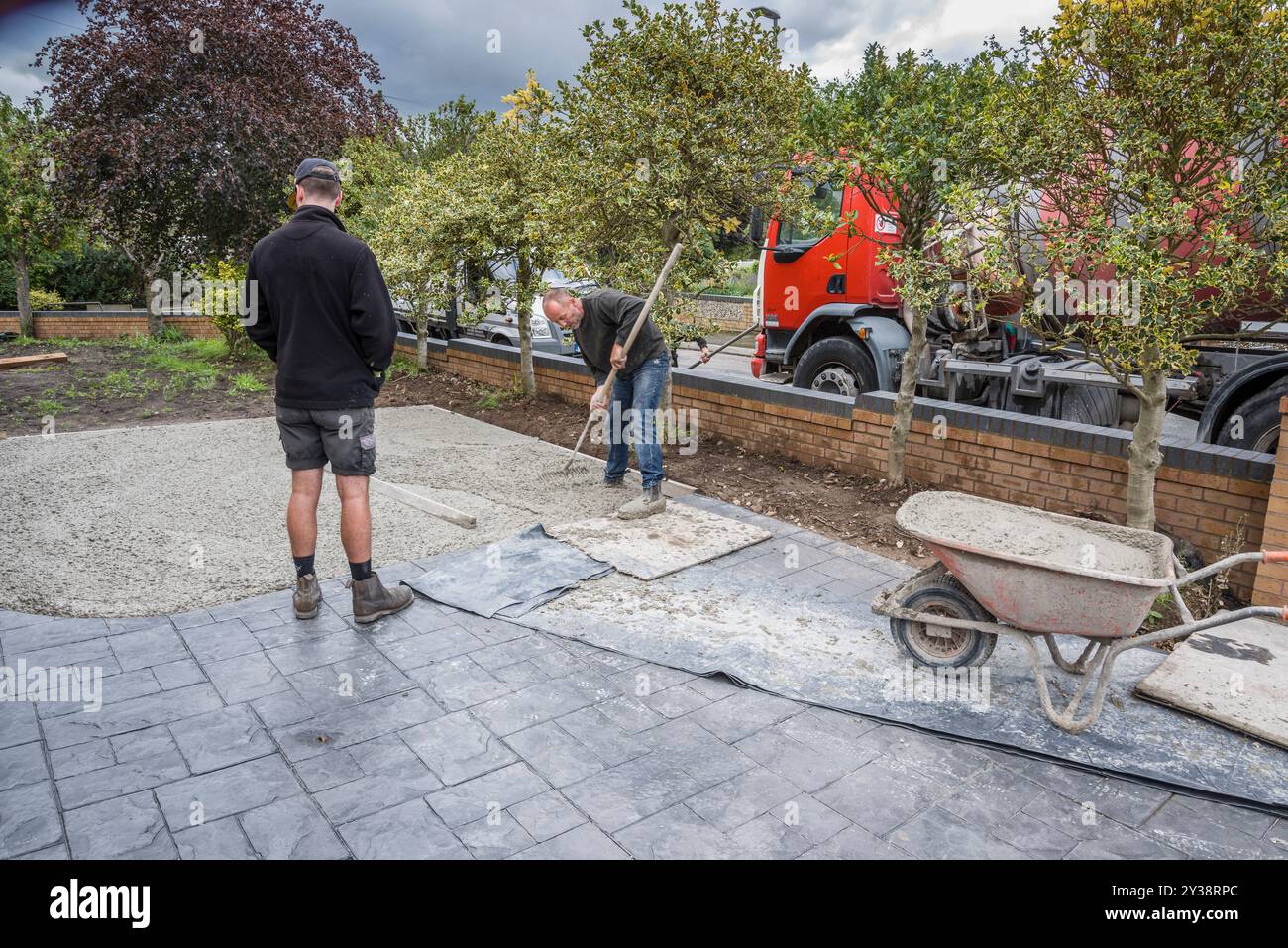 work men pouring concrete creating a new concrete driveway Stock Photo ...