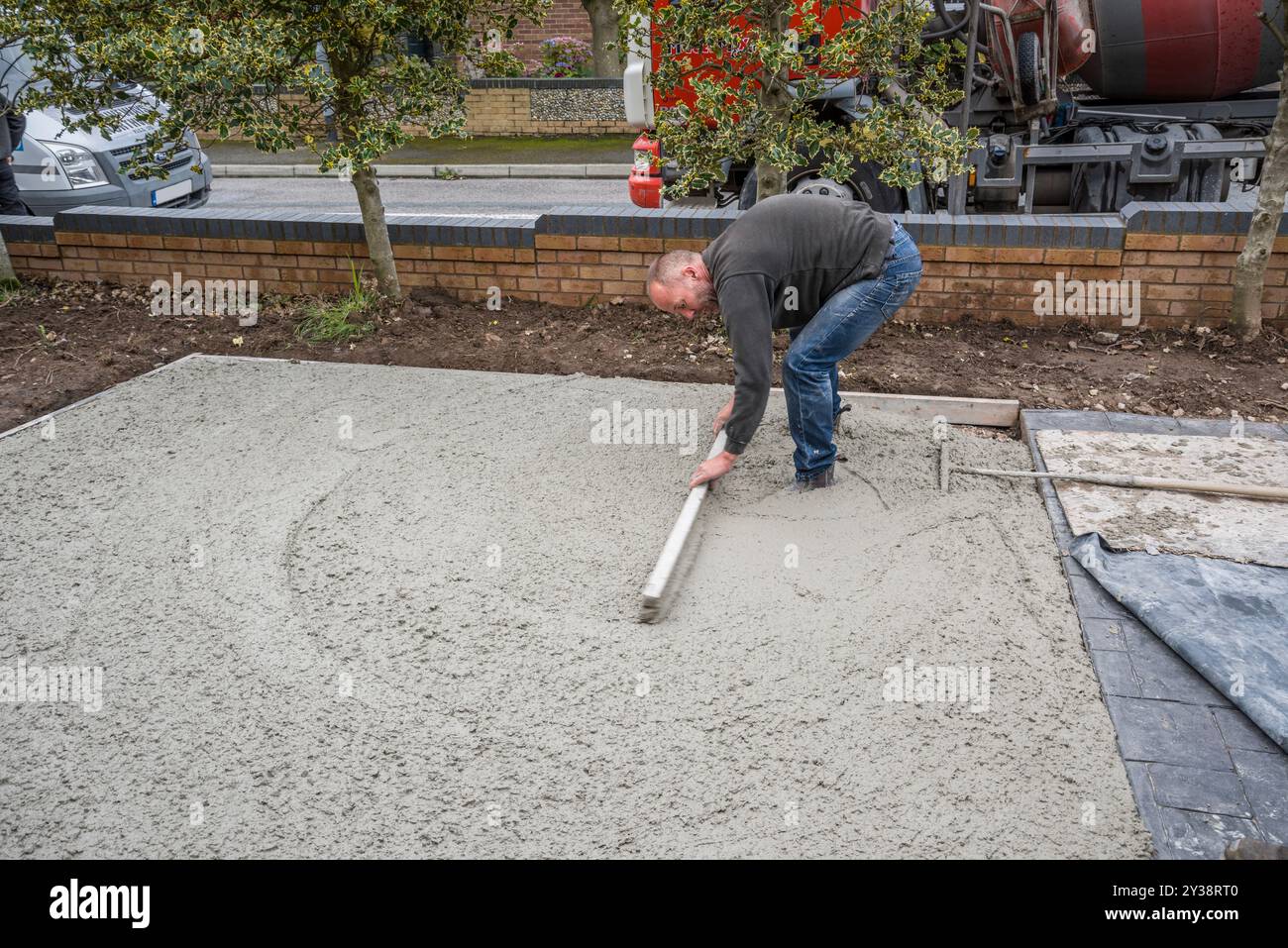 work men pouring concrete creating a new concrete driveway Stock Photo ...