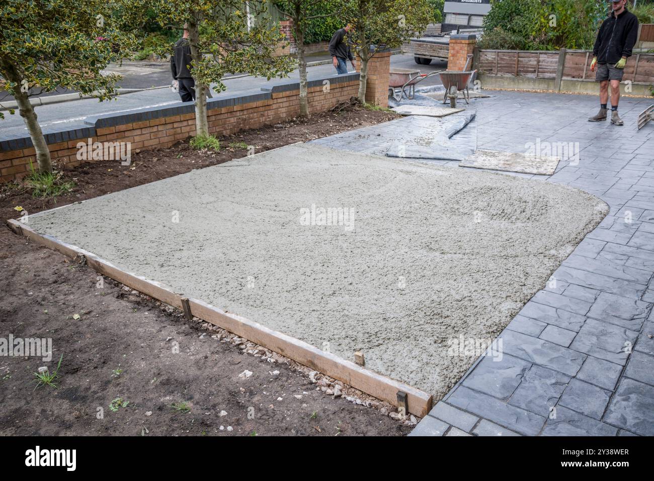 work men pouring concrete creating a new concrete driveway Stock Photo ...