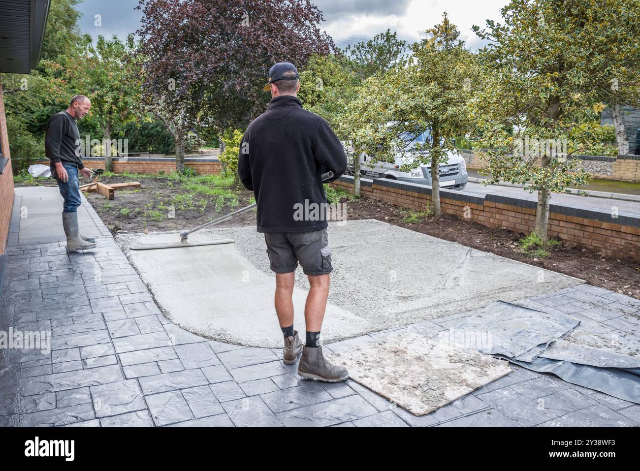 work men pouring concrete creating a new concrete driveway Stock Photo ...