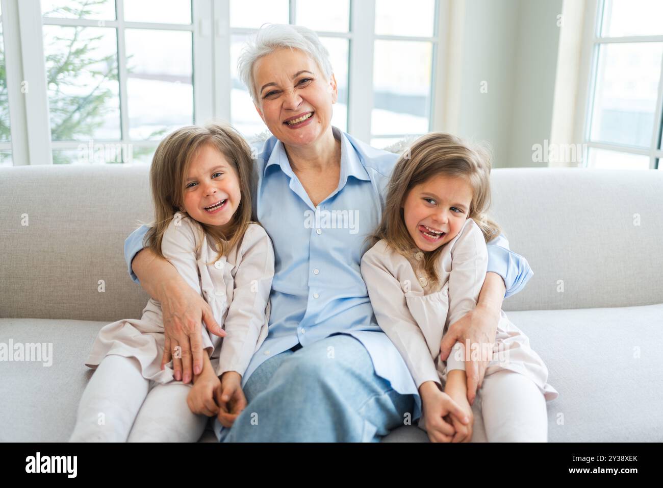 Happy family at home. Two little girls sisters twins grandmother ...