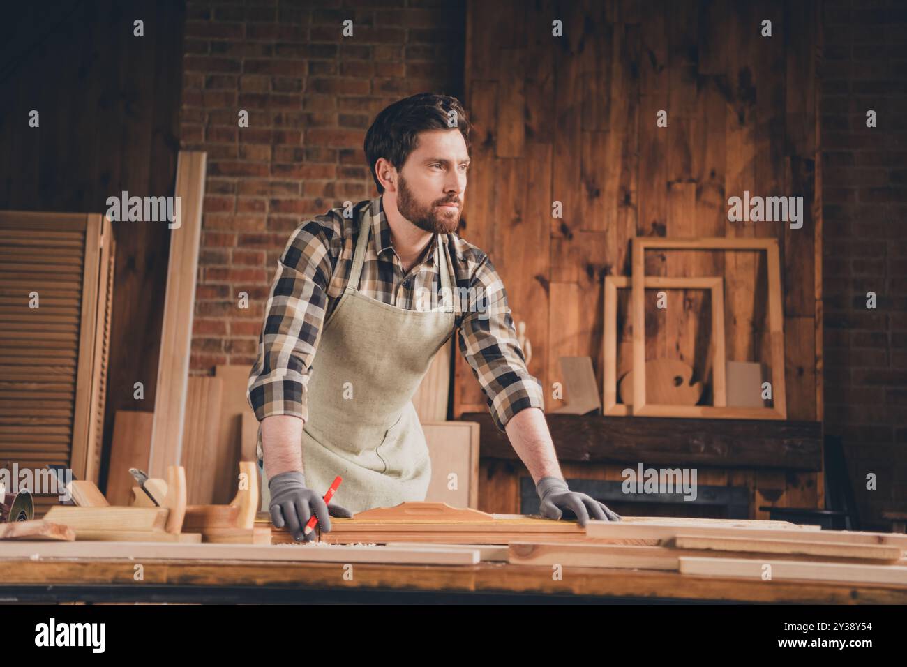 Photo of serious woodman working with wood plank look profile side in ...