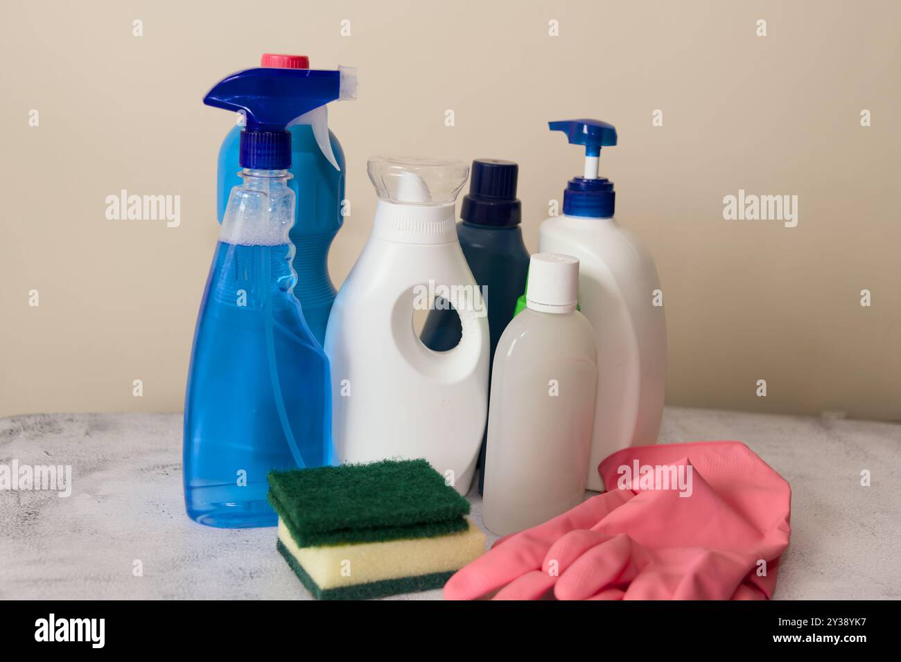Colorful cleaning products, gloves, and a sponge stand at attention ...