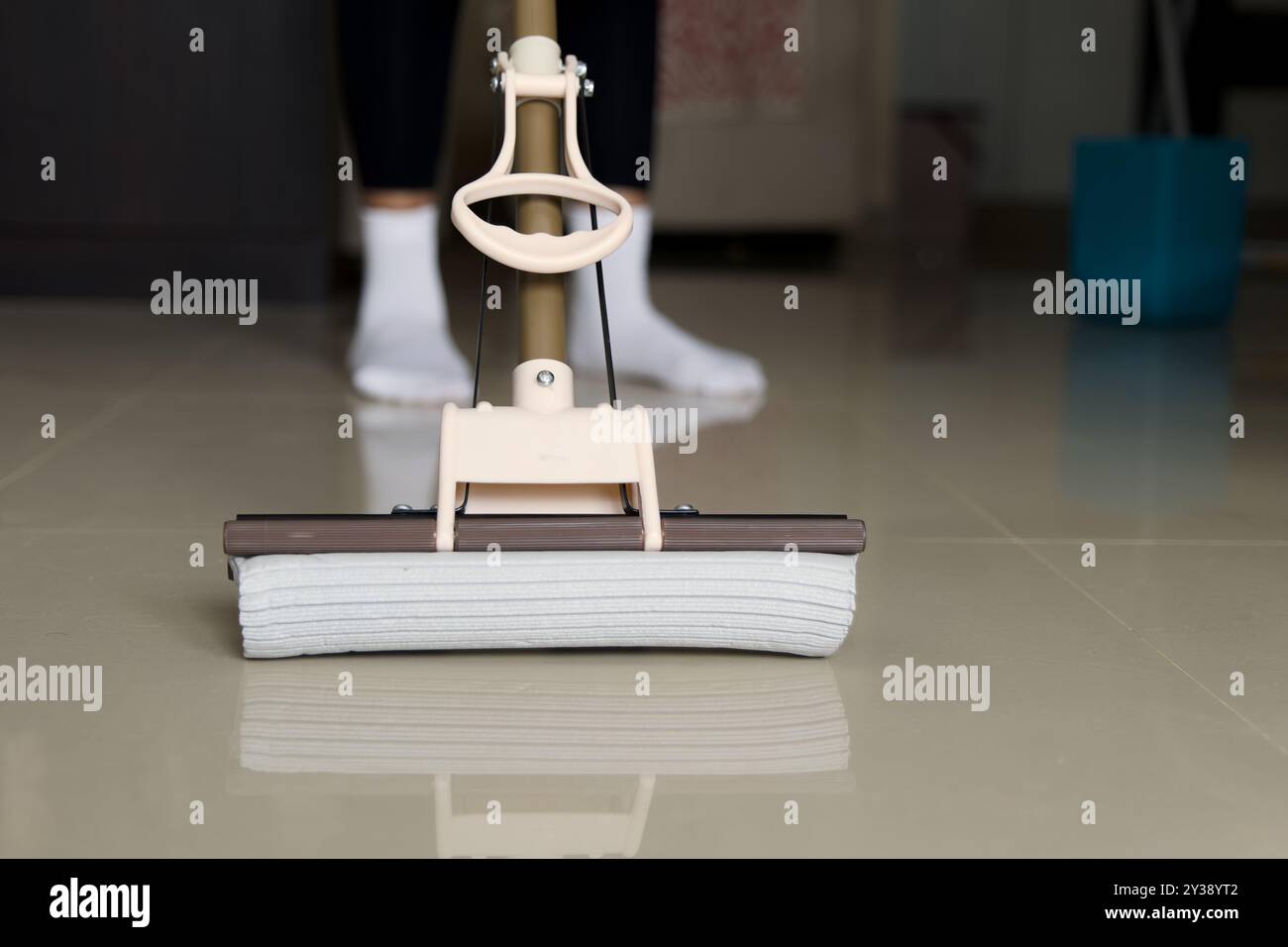 Detailed shot of a mop being used to clean a tiled floor, emphasizing ...