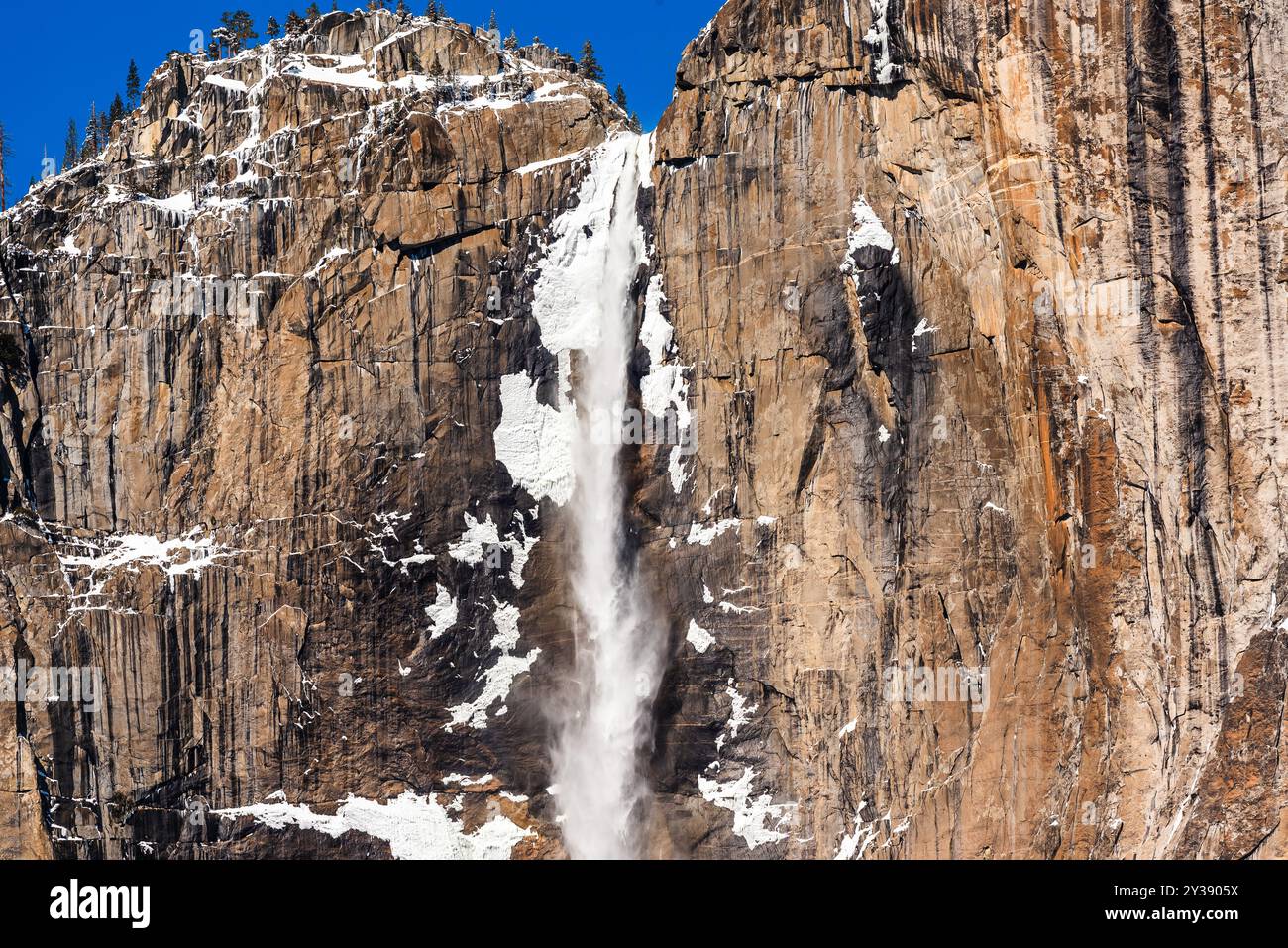 Yosemite's waterfall cascades over snowy El Capitan cliffs Stock Photo ...