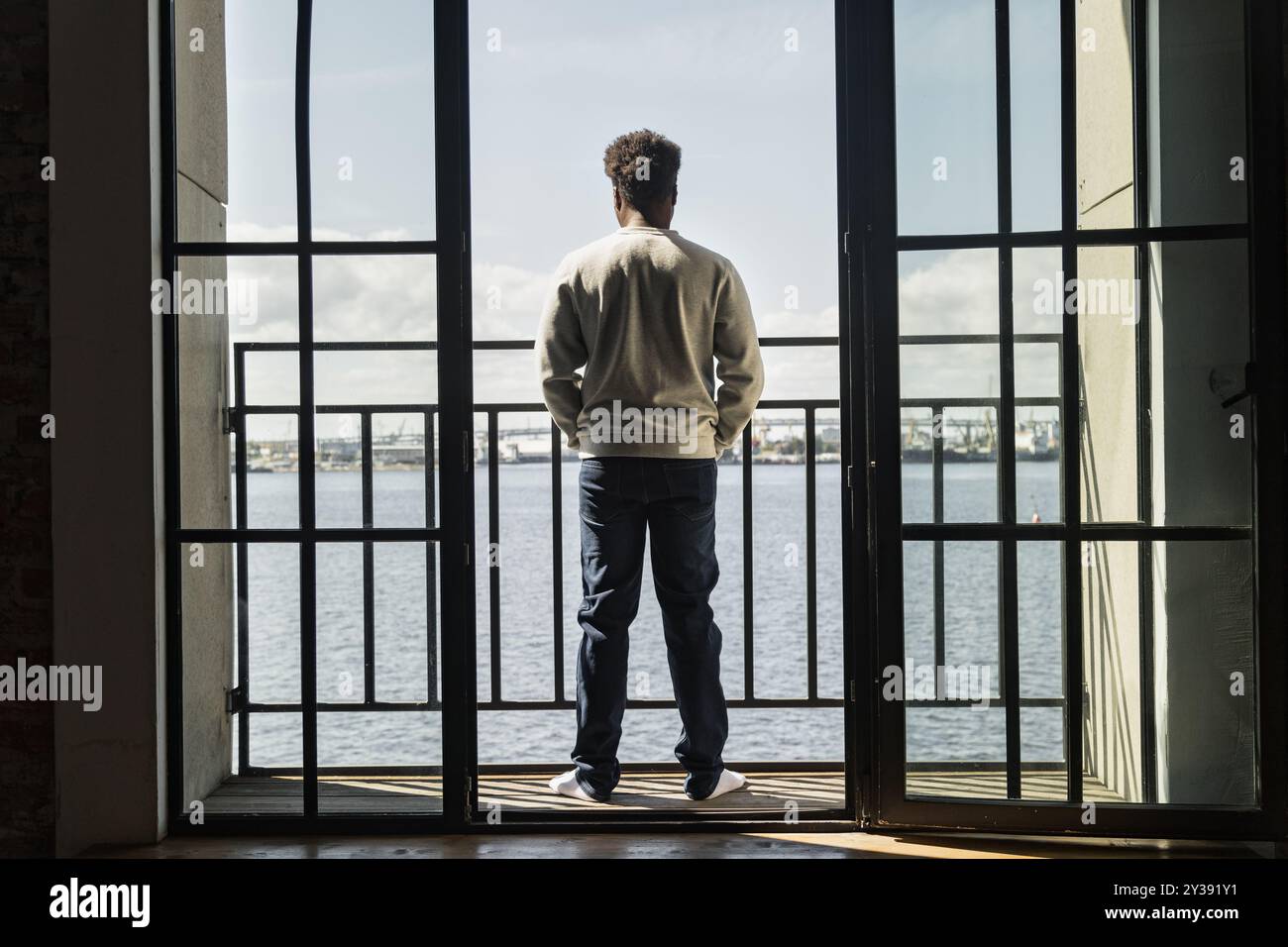 African American man in window looking on water pondering Stock Photo ...