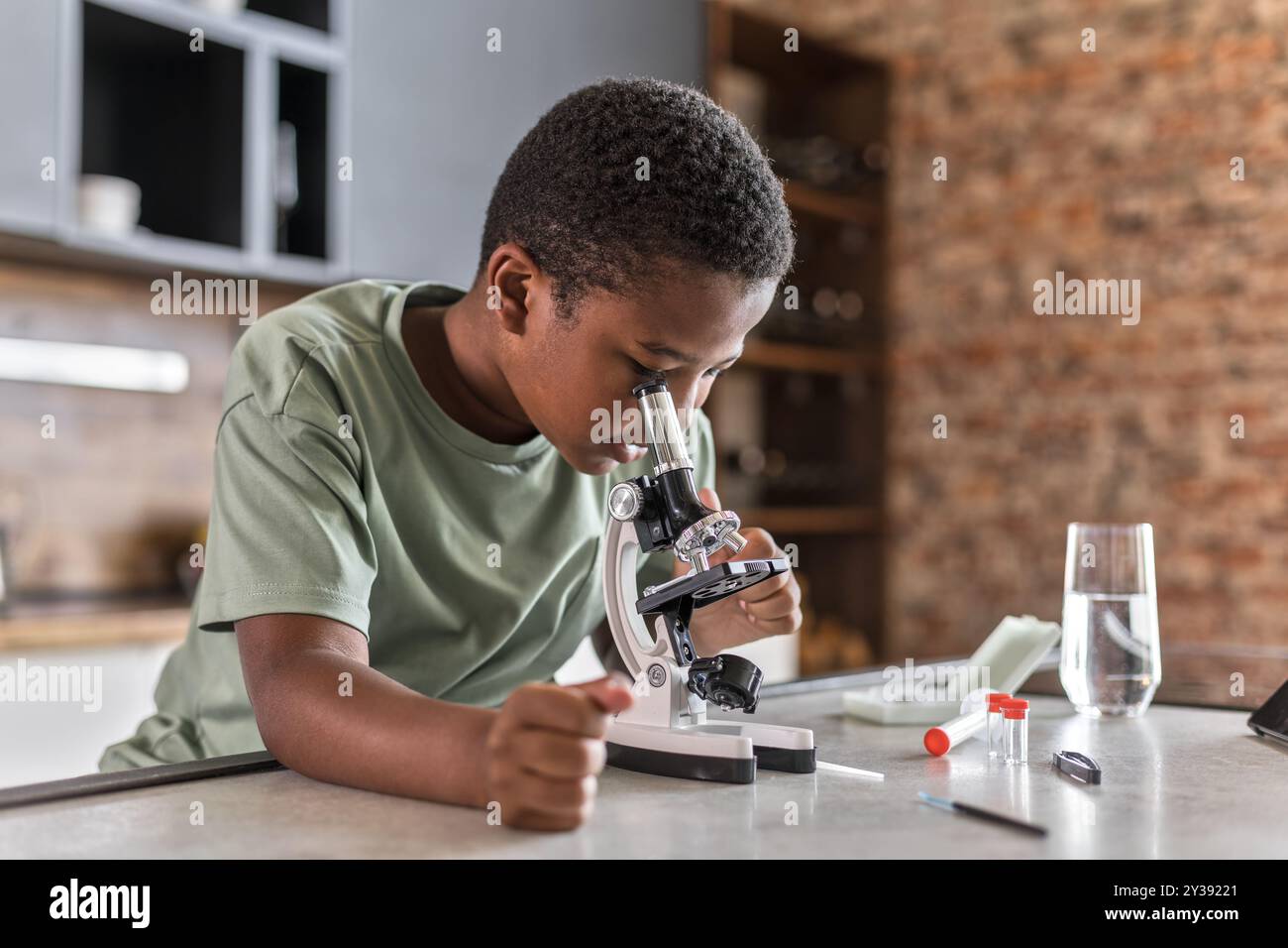 African American boy using microscope at home Stock Photo - Alamy