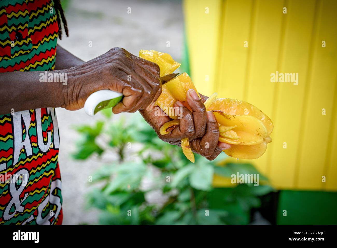 Man cutting fresh star fruit in a street market Stock Photo - Alamy