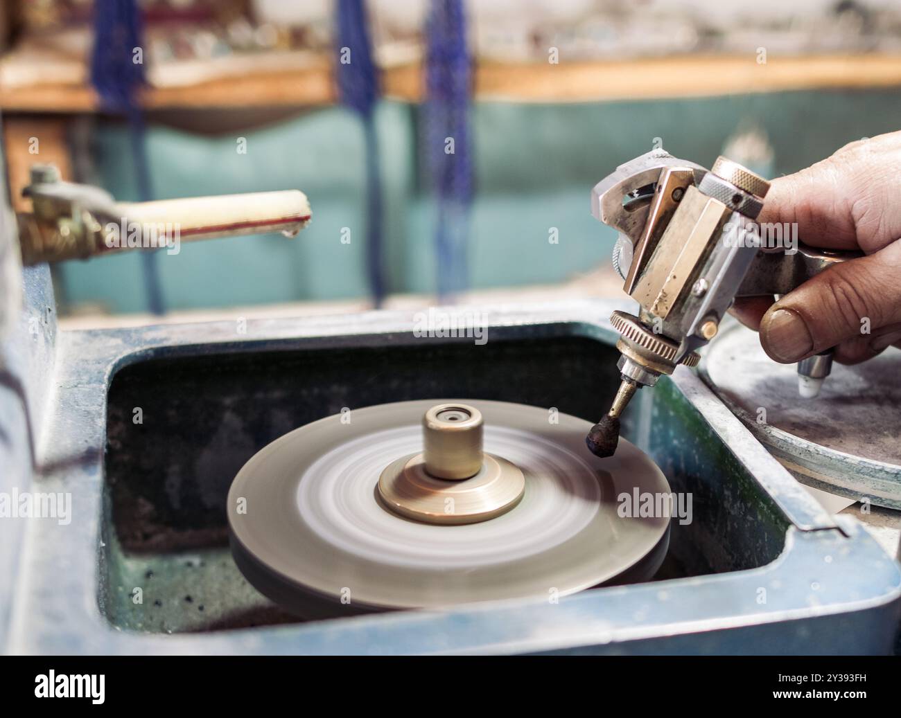 A man is holding a tool that is used to sharpen objects and stones ...