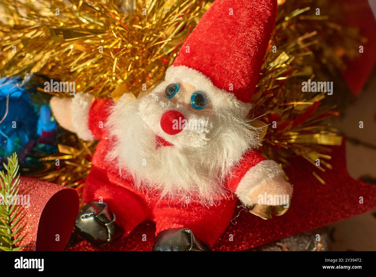 Santa Claus plush toy sitting amidst a festive Christmas scene. The ...