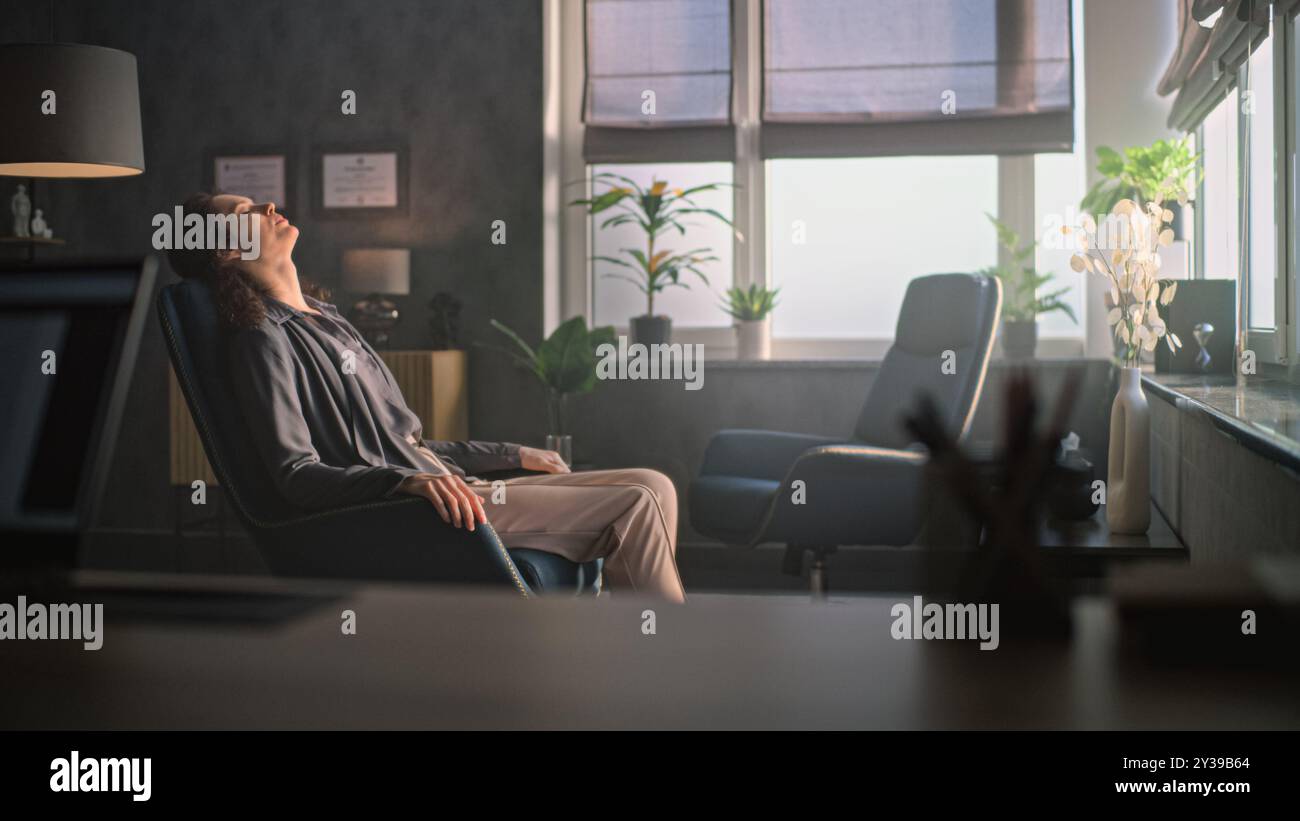 Tired female psychologist sits in chair and rests in stylish ...