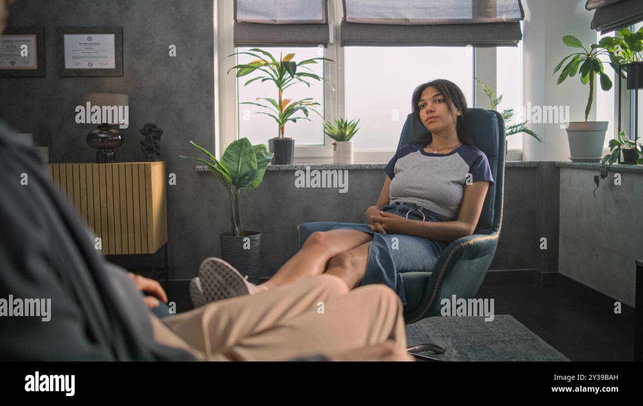 Relaxed African American teen girl sits in chair, shares positive ...