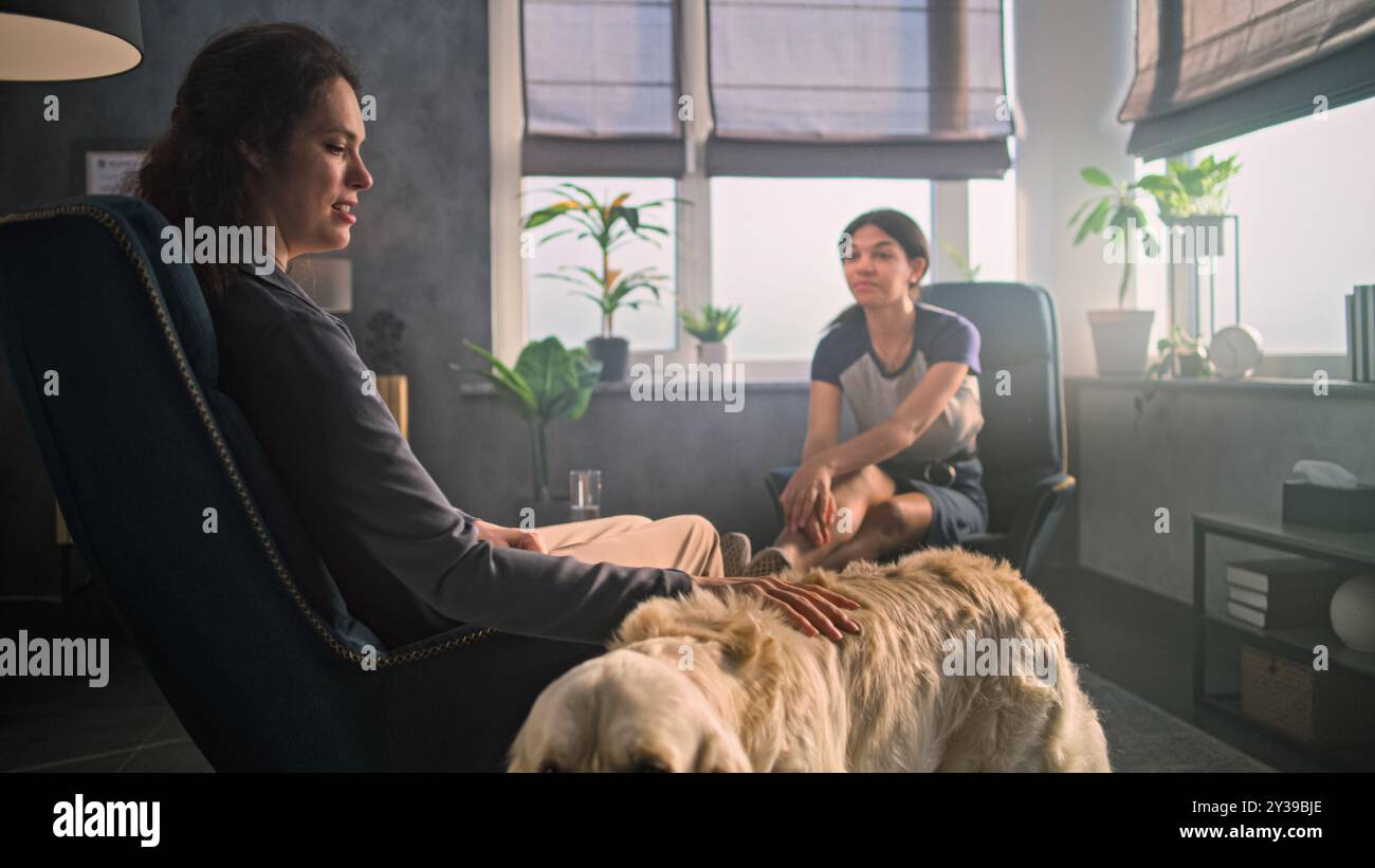 African American teen girl sits in chair, talk to psychologist during ...
